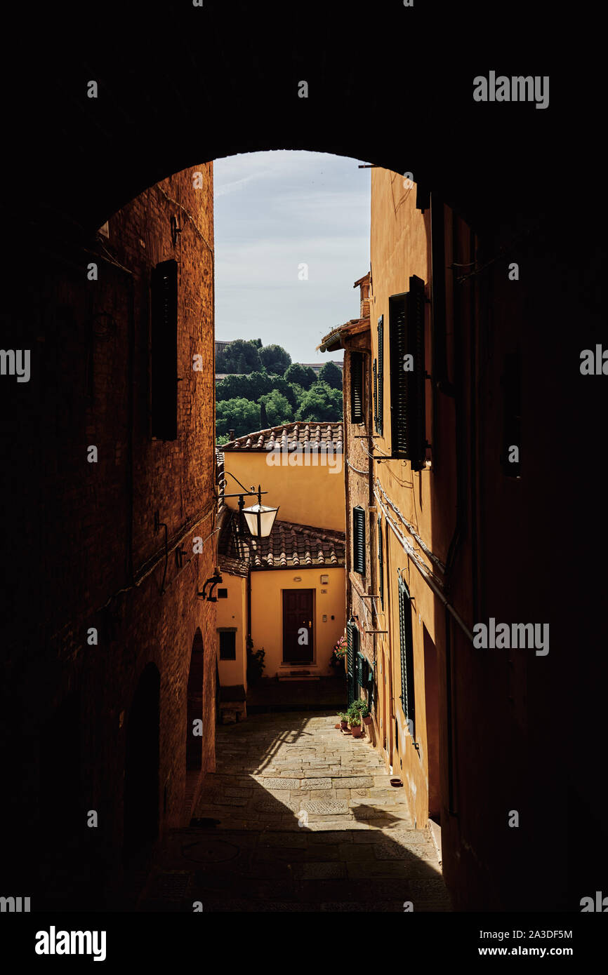 Shady alley and archway to ancient houses in medieval town in Italy ...