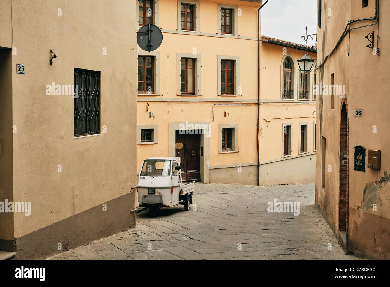 Narrow lane with old white tricycle parked between shabby houses in ...