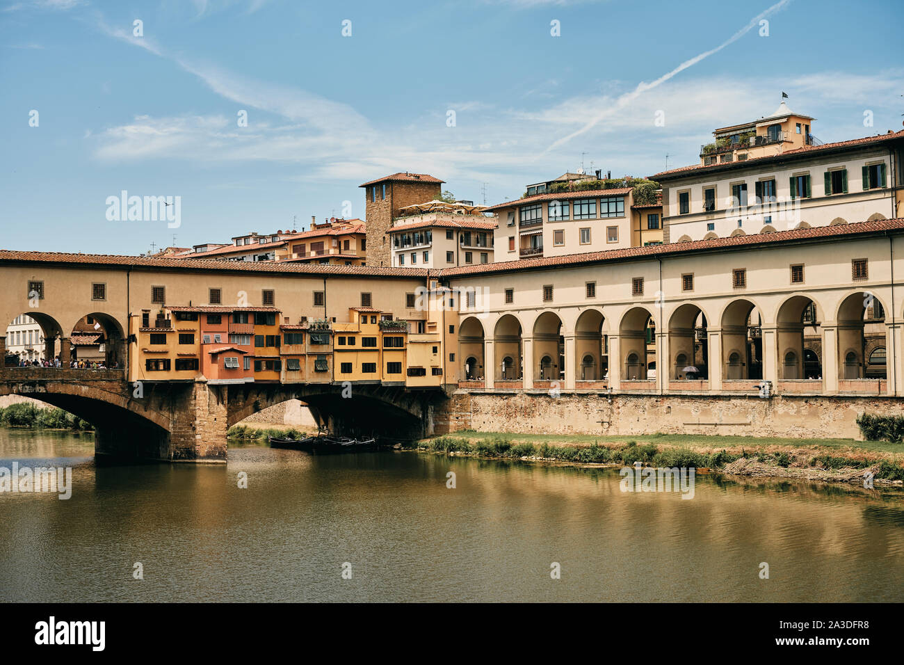 Picturesque channel with arched ancient bridge above rippled water on ...