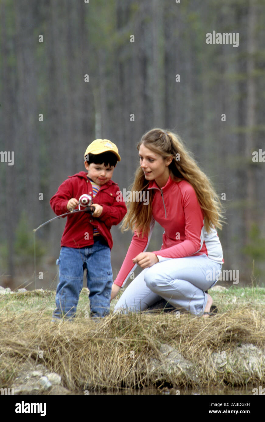 Mother helping her young son fish in a pond near West Glacier, MT Stock ...