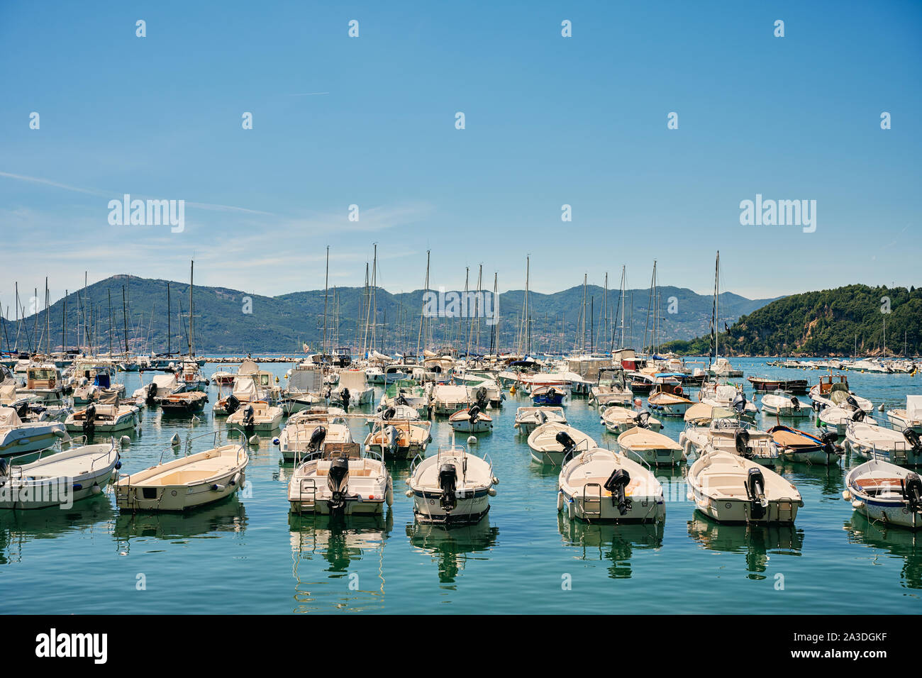 Various vessels floating in idyllic quay by hilly coast at summer day ...
