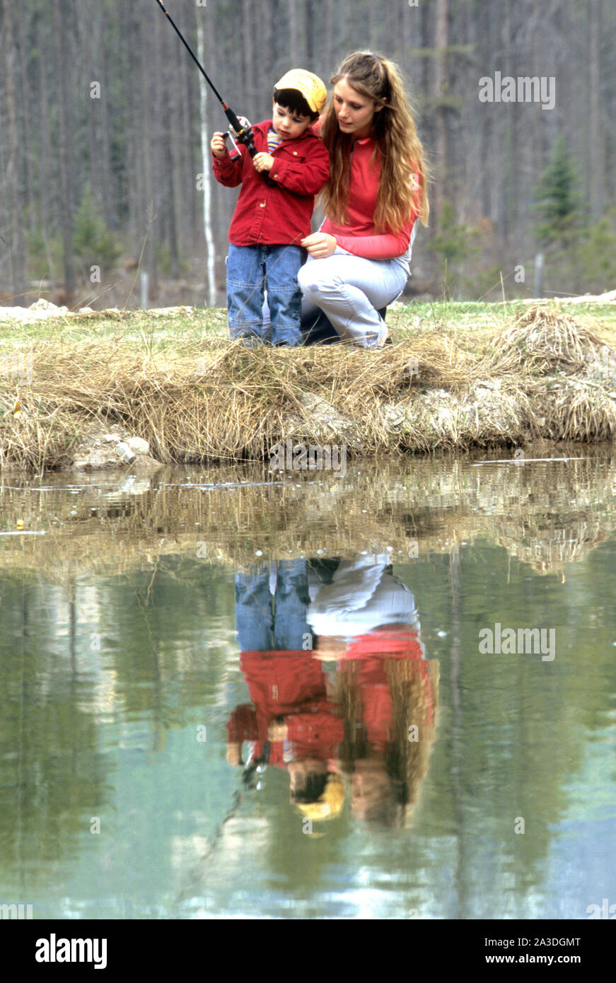 Mother helping her young son fish in a pond near West Glacier, MT Stock ...