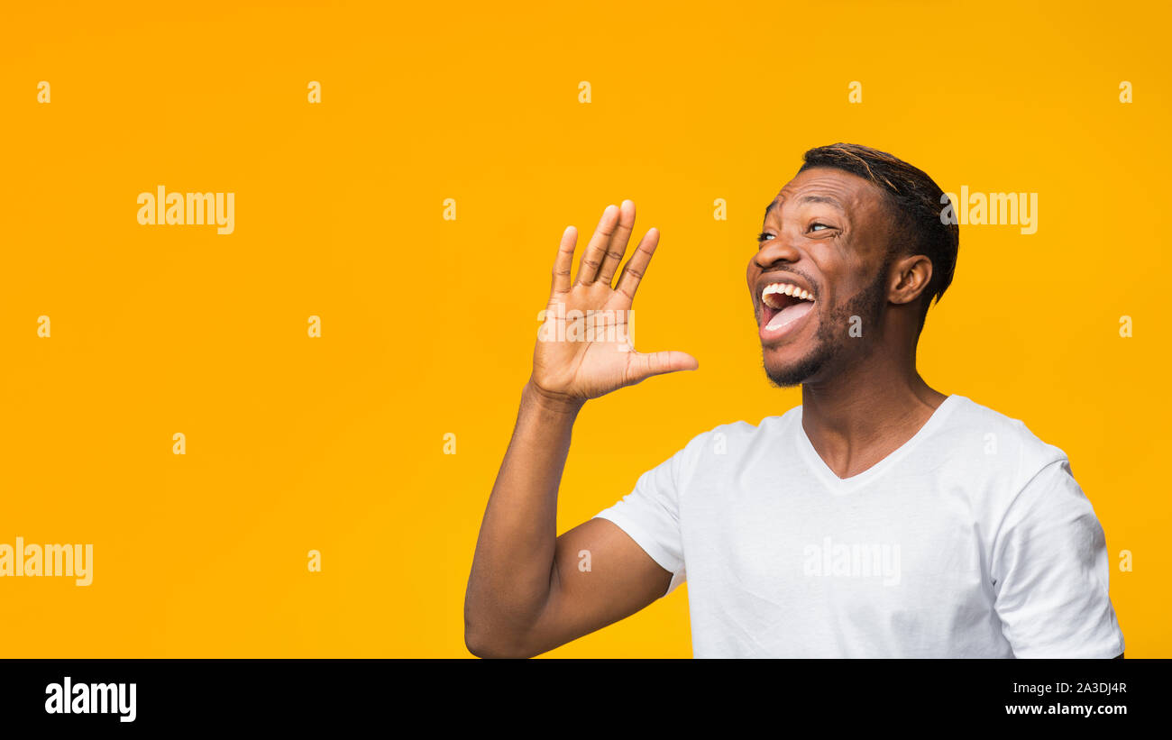 Black Man Shouting Holding Hand Near Mouth Standing In Studio Stock ...
