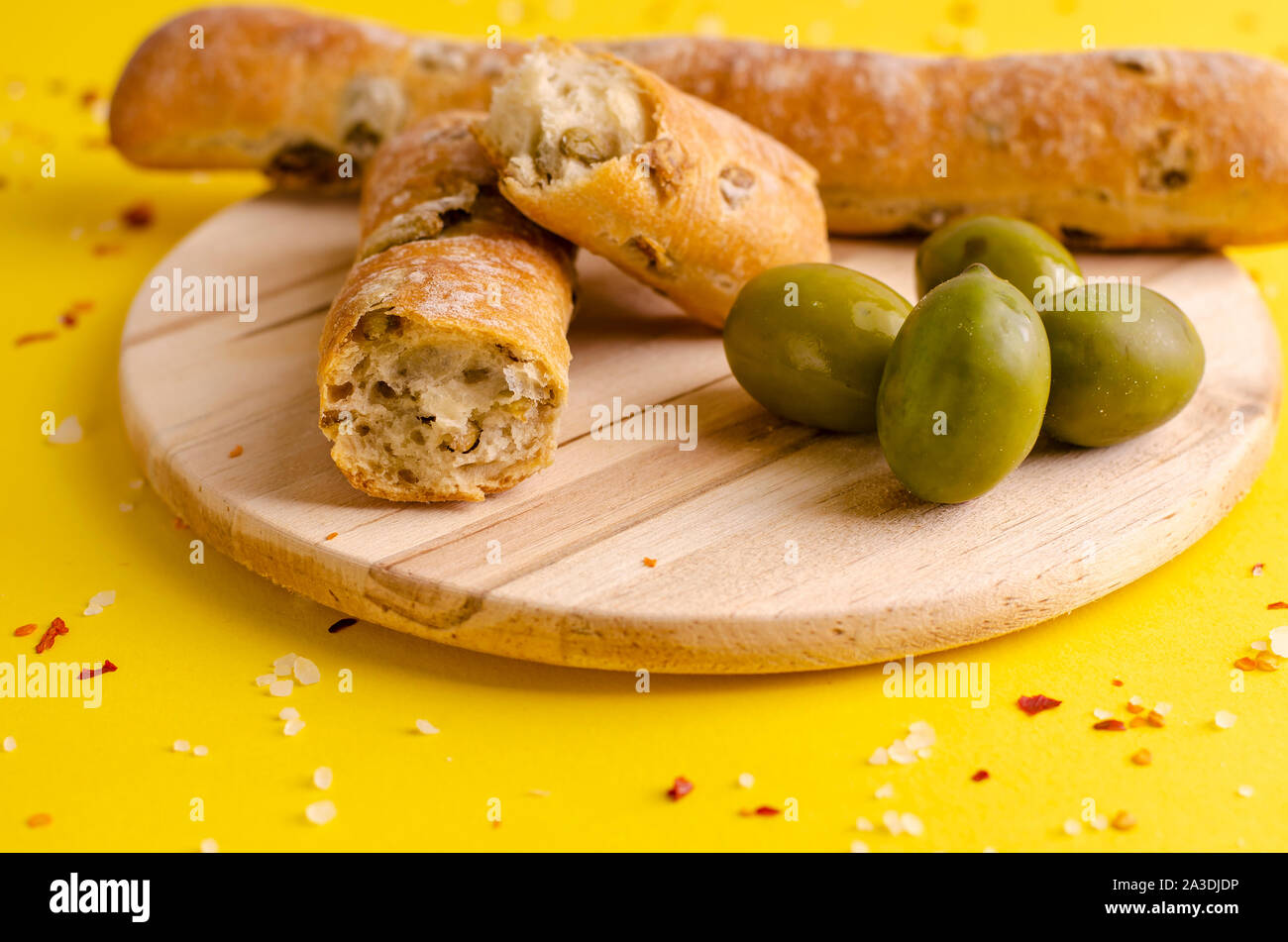 Italian rustic olive bread sticks on yellow background with copy space ...
