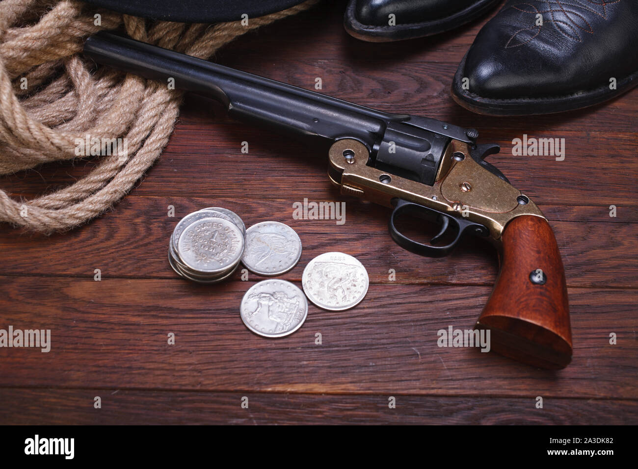Old western gun with silver dollars with hat, rope and boots Stock ...