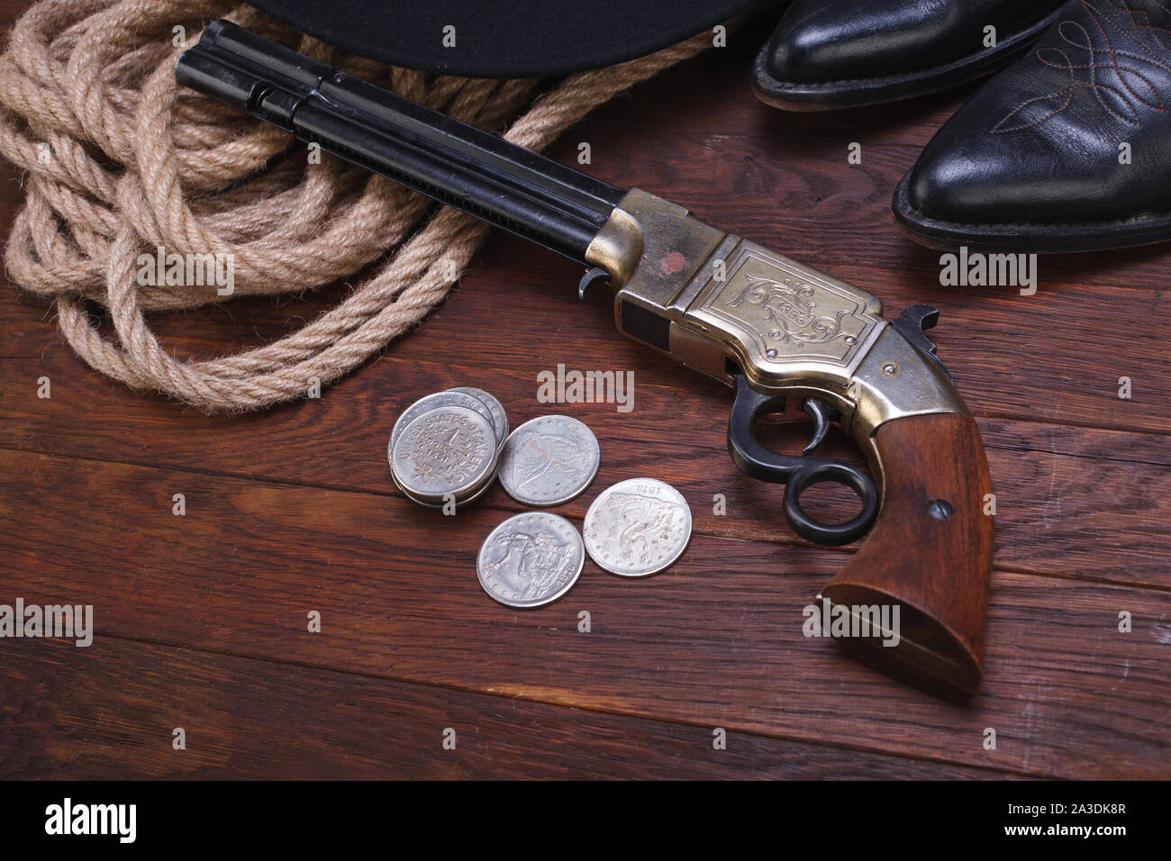 Old western gun with silver dollars with hat, rope and boots Stock ...