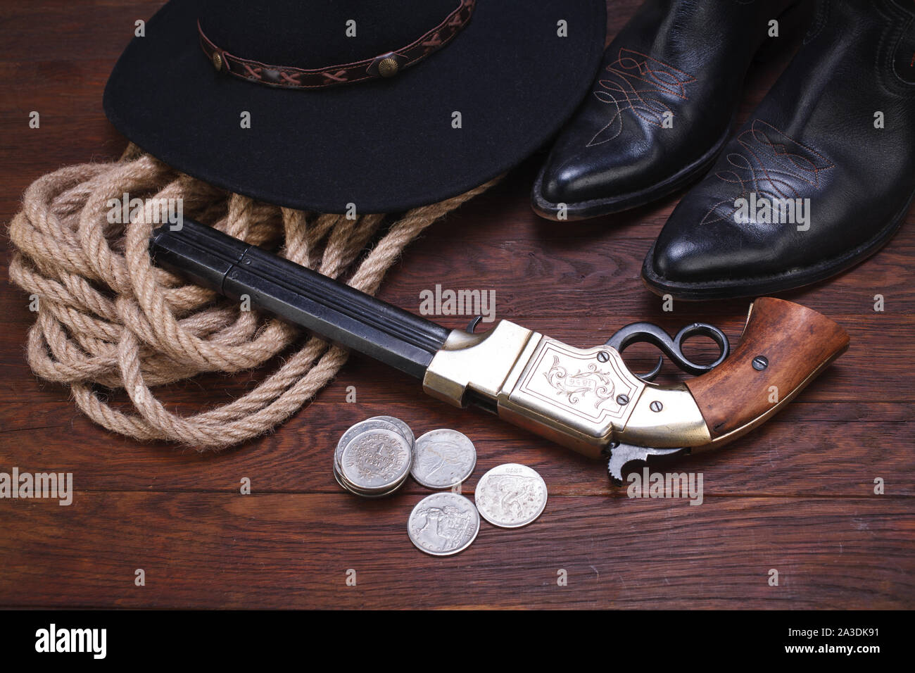 Old western gun with silver dollars with hat, rope and boots Stock ...