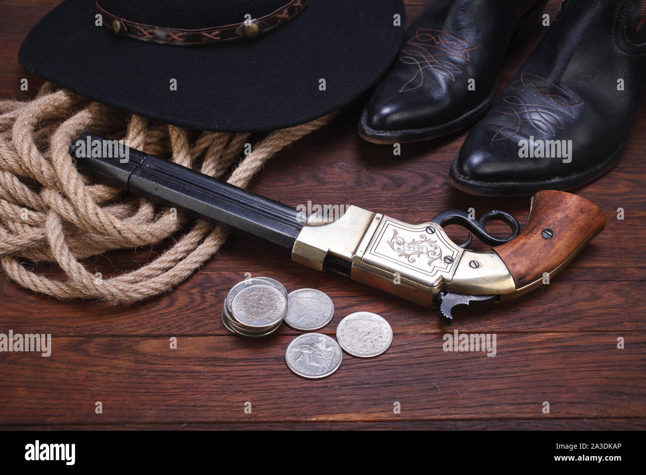 Old western gun with silver dollars with hat, rope and boots Stock ...
