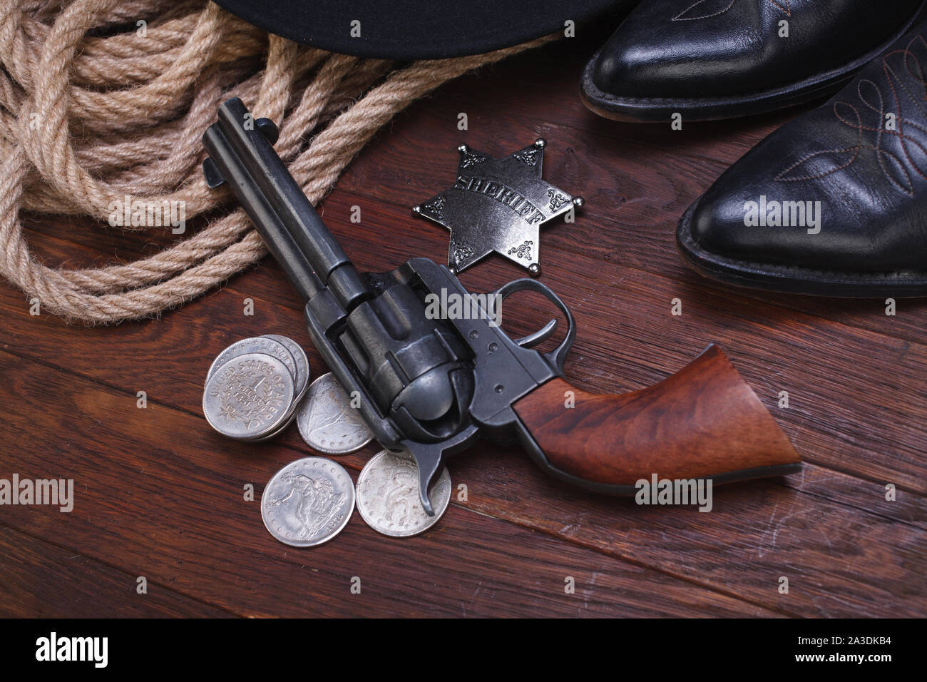 Old western gun with sheriff badge and silver dollars with hat, rope ...