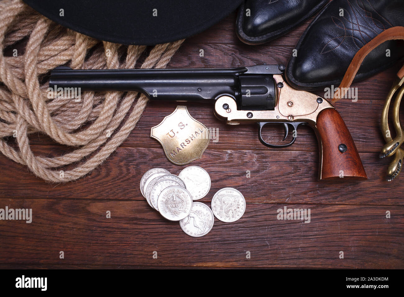 Old western gun with marshal badge and silver dollars with hat, rope ...