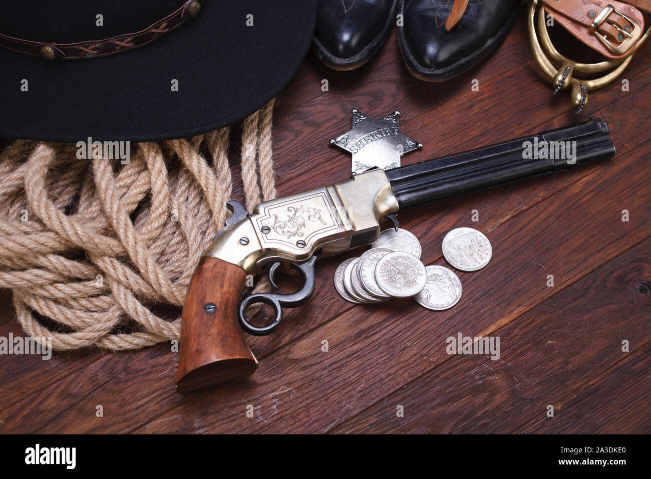 Old western gun with sheriff badge and silver dollars with hat, rope ...
