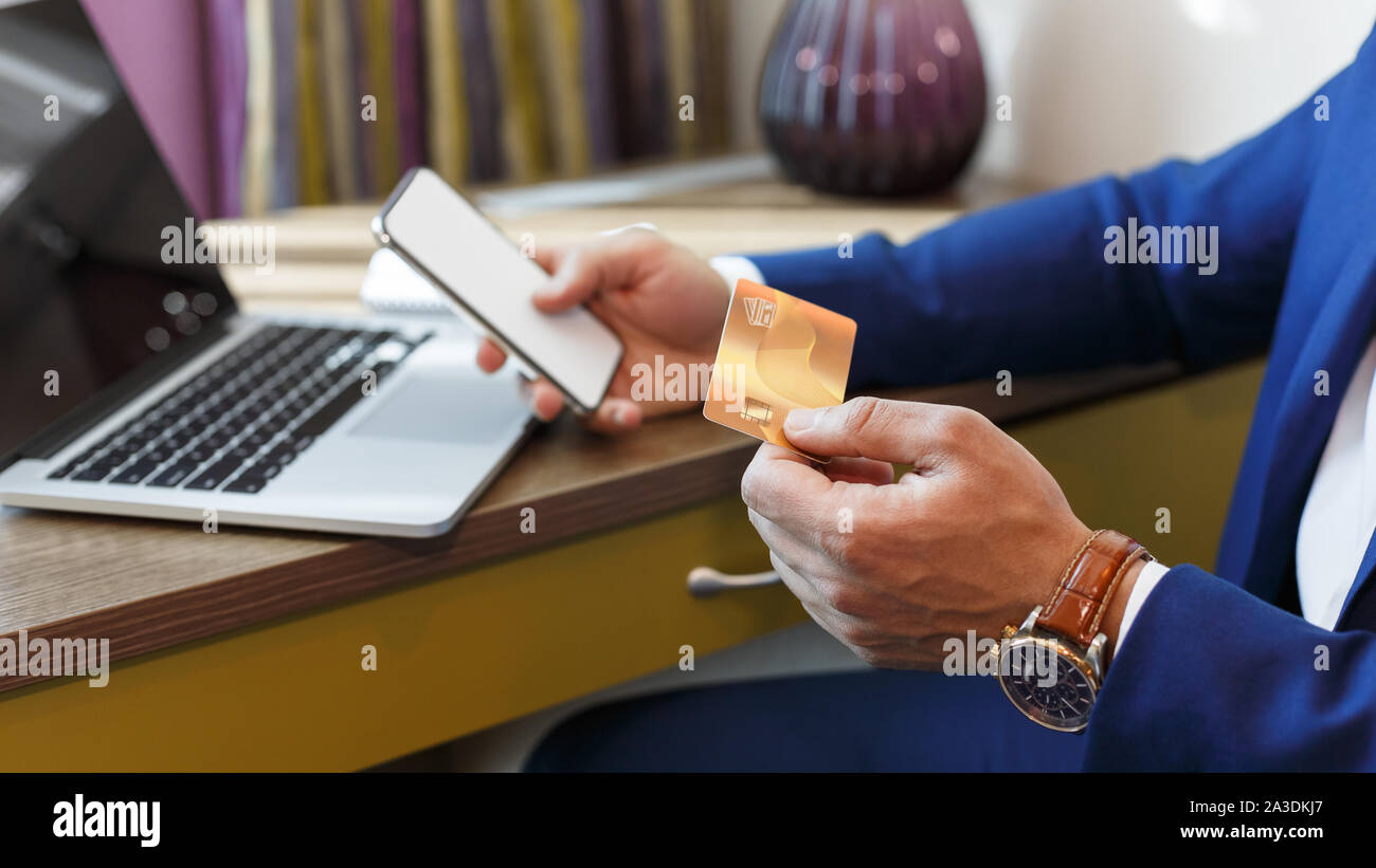 Man holding credit card and cellphone, making online payments Stock ...