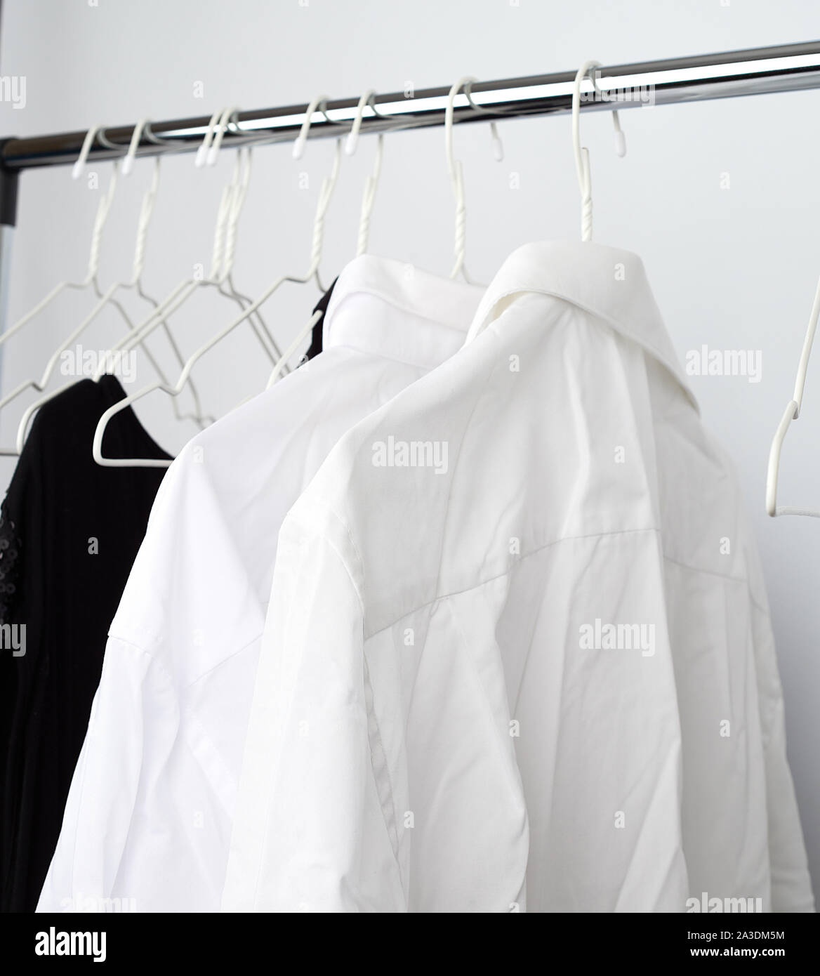 white men's crumpled shirts hanging on a metal hanger, white background ...