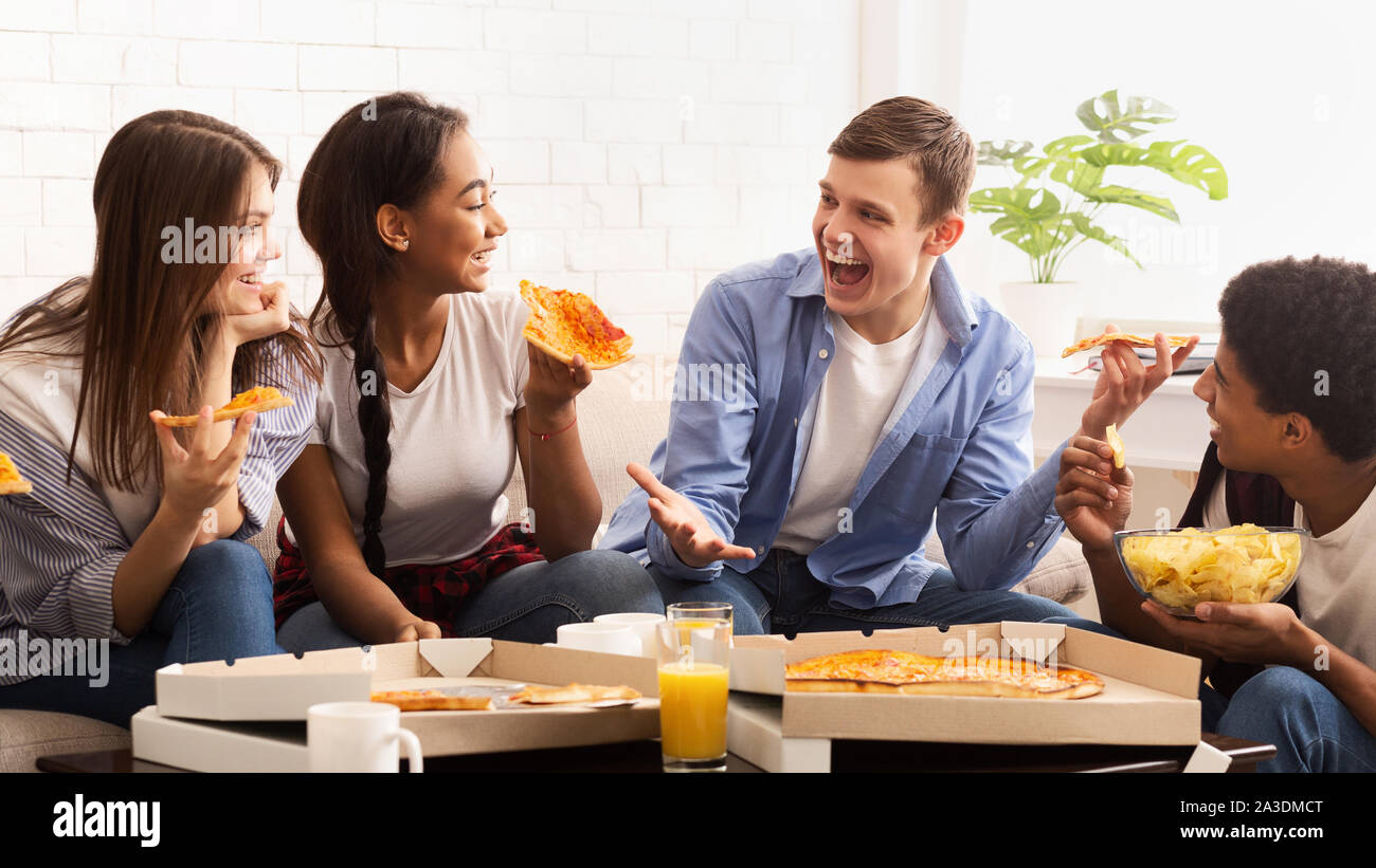 Excited teenagers eating pizza and talking at home Stock Photo - Alamy