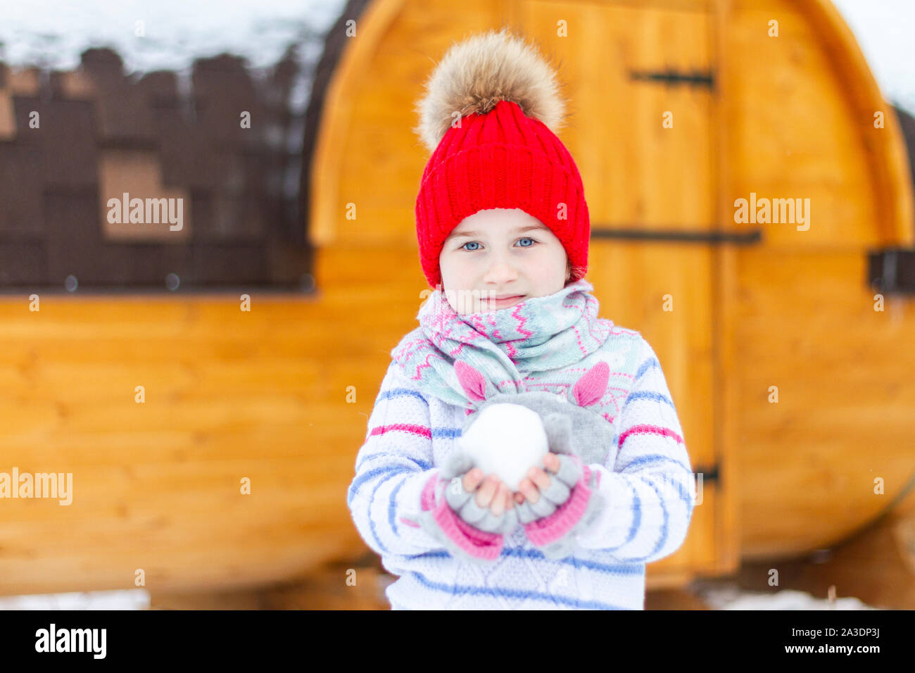 girl in a hat sculpts snow from the first snow Stock Photo - Alamy