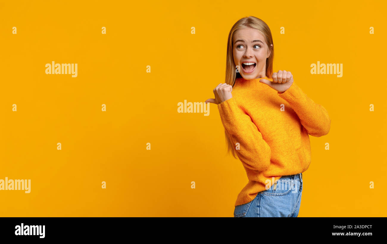 Cheerful cute girl pointing on copy space behing her back Stock Photo ...
