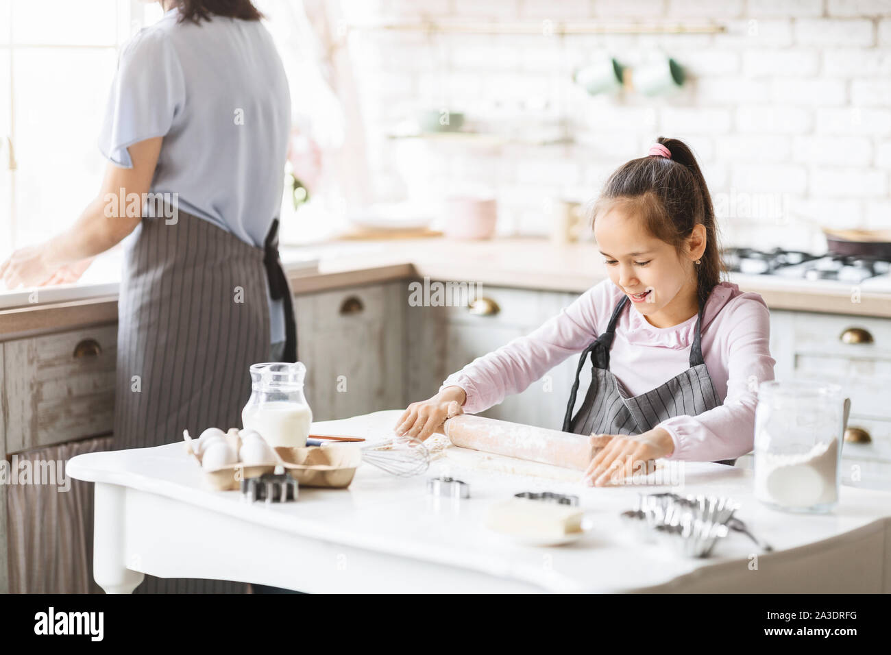 Little girl learning how to use rolling pin Stock Photo - Alamy