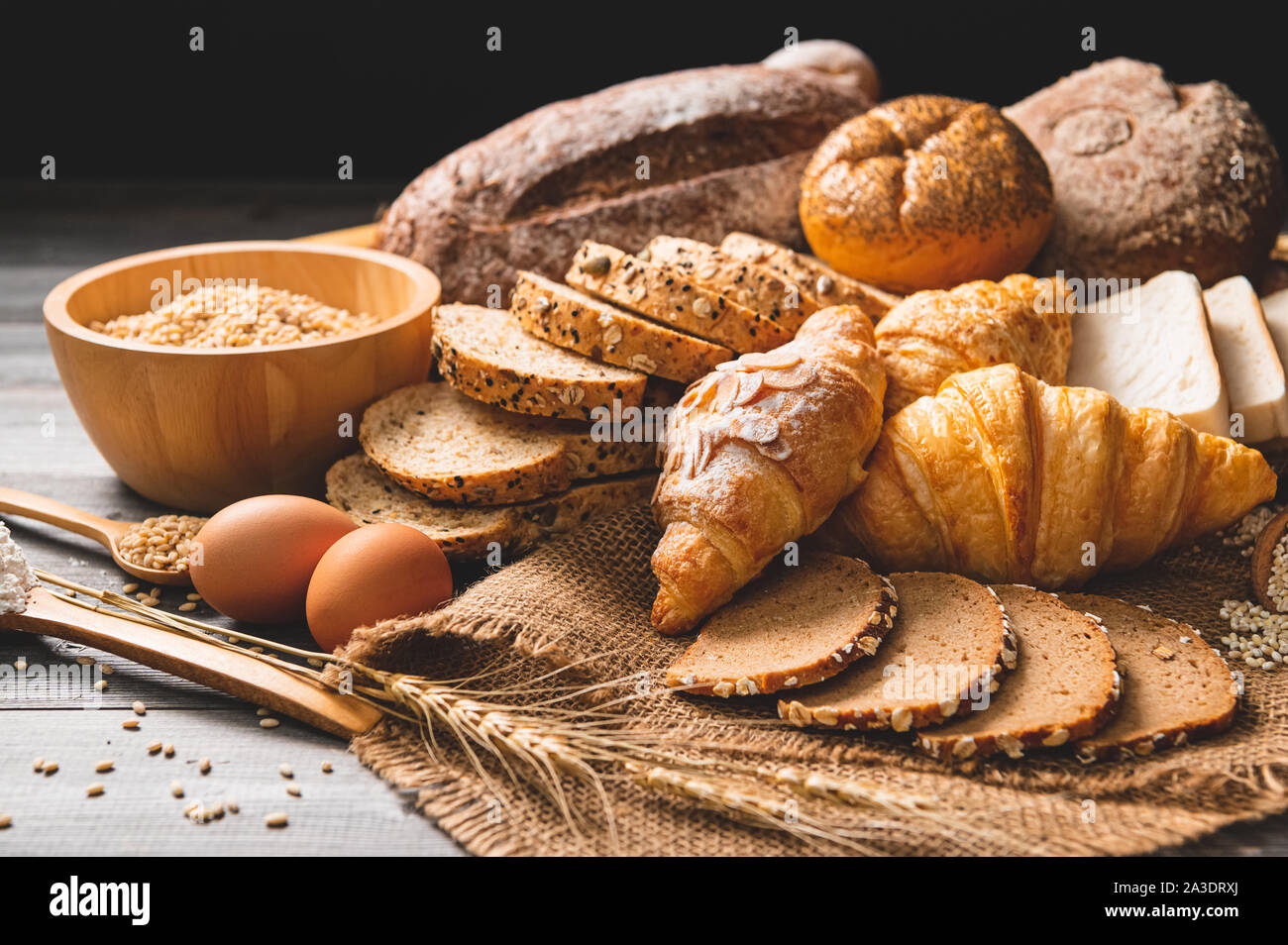 Different kinds of bread with nutrition whole grains on wooden ...
