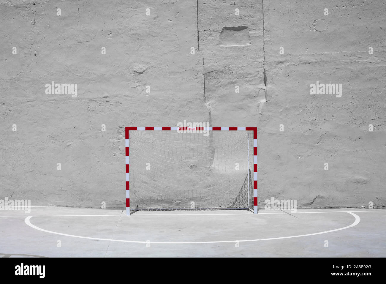 Soccer ball and goal with net against plastered wall background ...