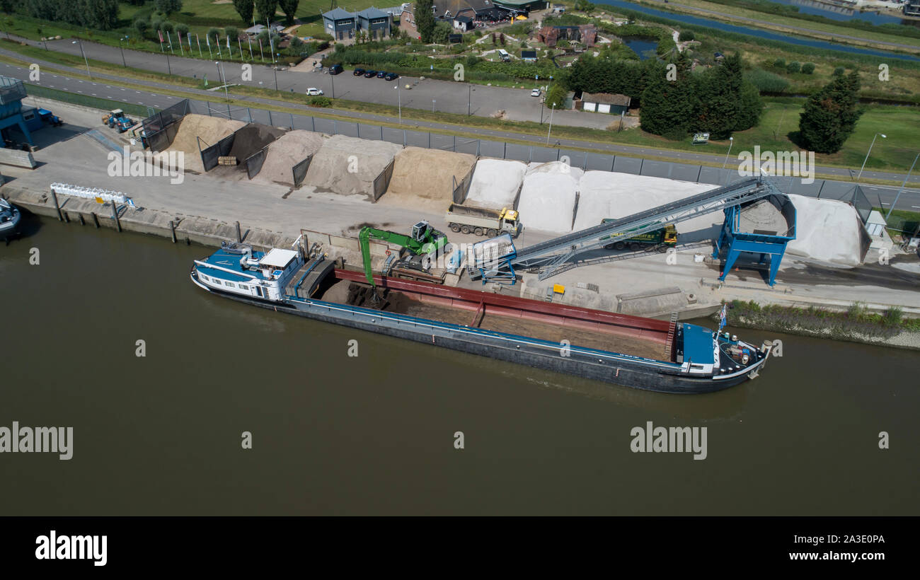 Loading barge with sand and rubble on a small berth. Freight transport ...