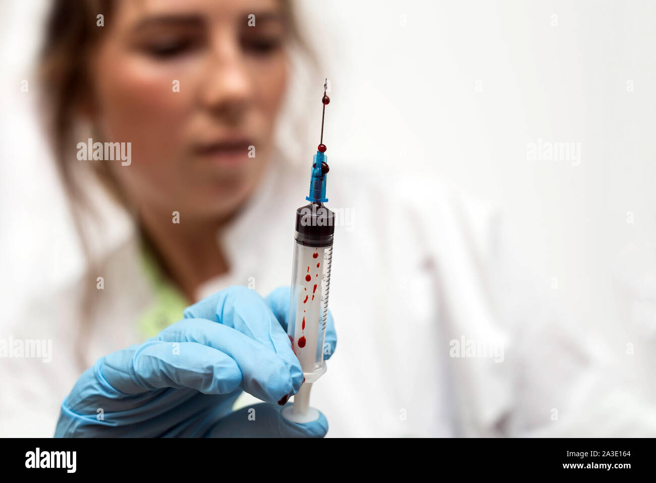 Closeup of nurse's hands with syringe of blood for cure disease ...