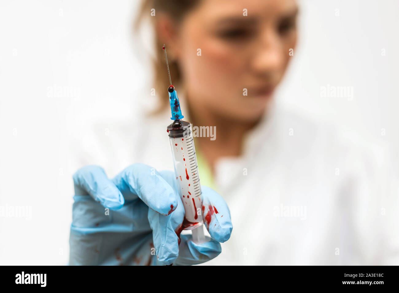 Closeup of nurse's hands with syringe of blood for cure disease ...