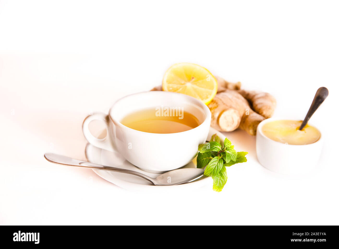 Cup of fresh ginger tea with honey, mint and cut ginger root isolated ...