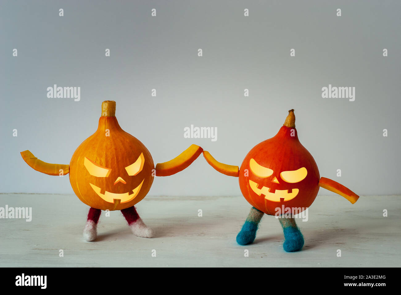 Red and orange pumpkin with halloween face, legs and hands holding ...
