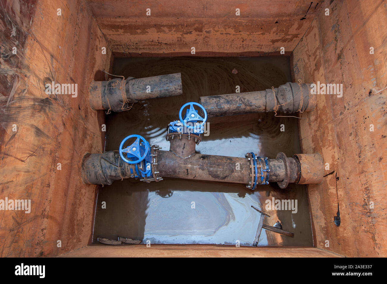 Rupture of a water pipe in a square well with water. Blue valves with ...