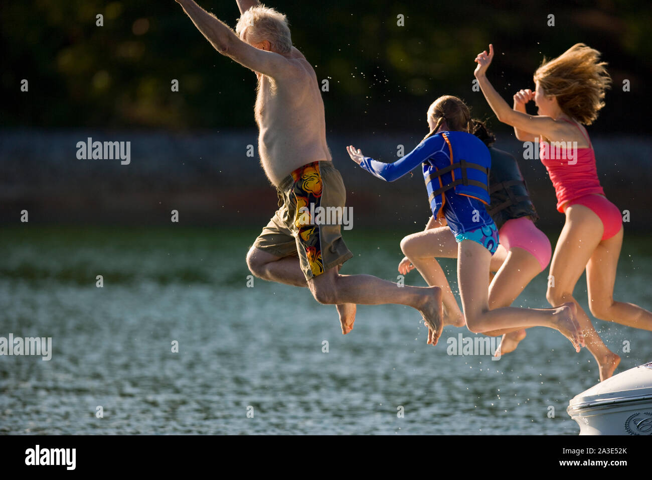 Family jumping into a lake Stock Photo - Alamy
