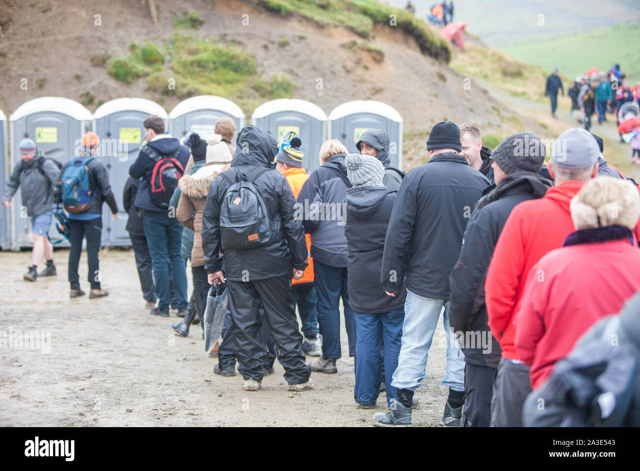 On,a,wet,rainy,day,Standing,waiting,in,line,Q,Queue,to,use,portable ...