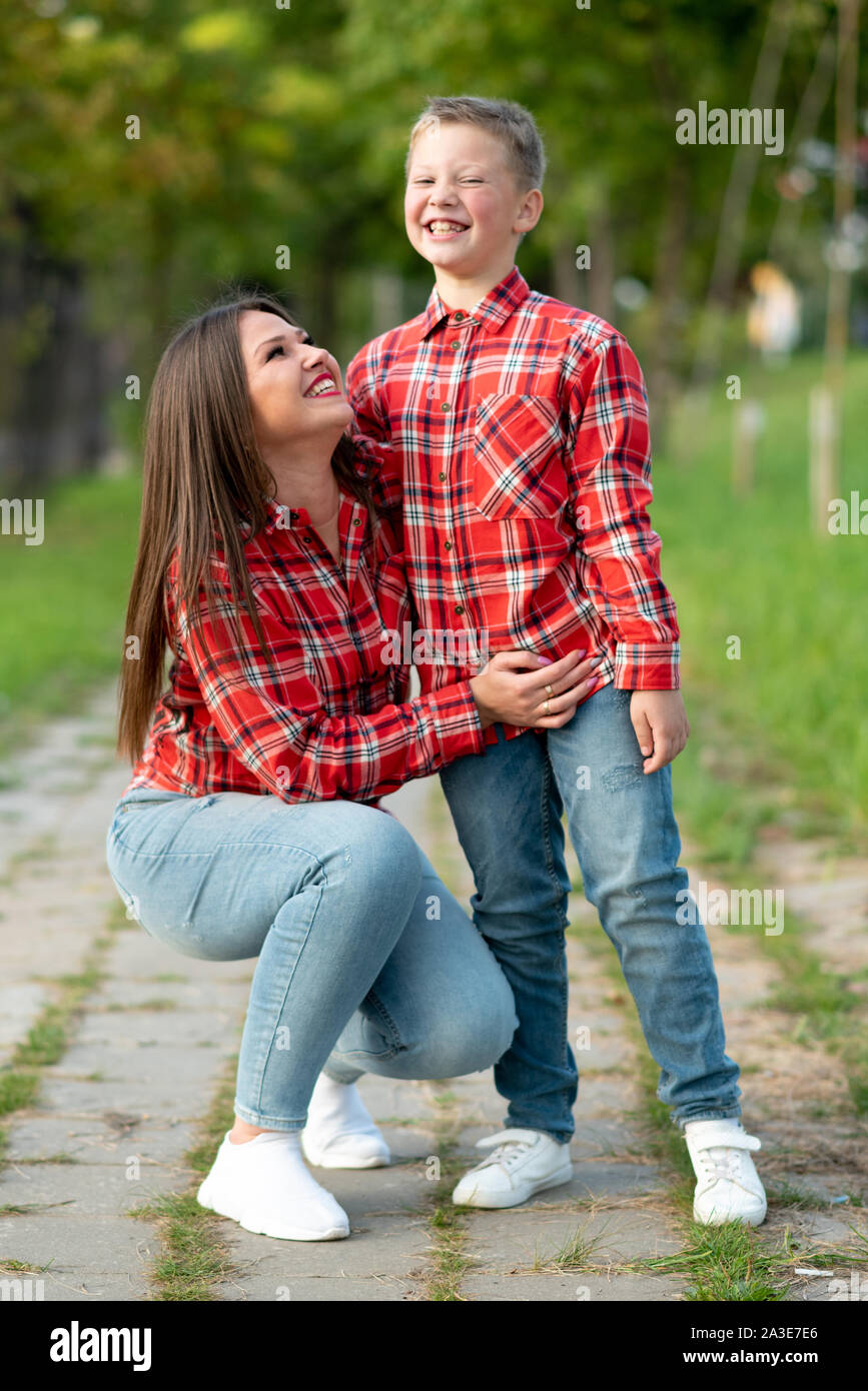 Mom and son are smiling happily on a walk in the park Stock Photo - Alamy