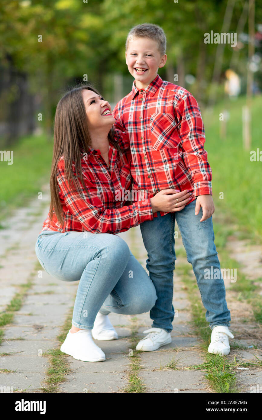 Mom and son are smiling happily on a walk in the park Stock Photo - Alamy