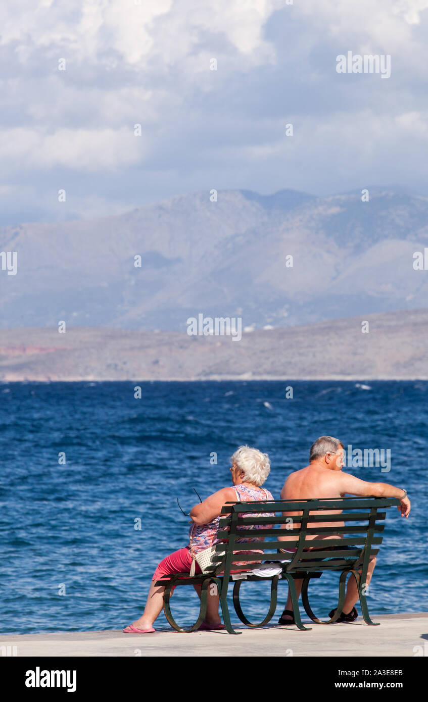 Man and woman sitting back to back facing in opposite directions on a ...