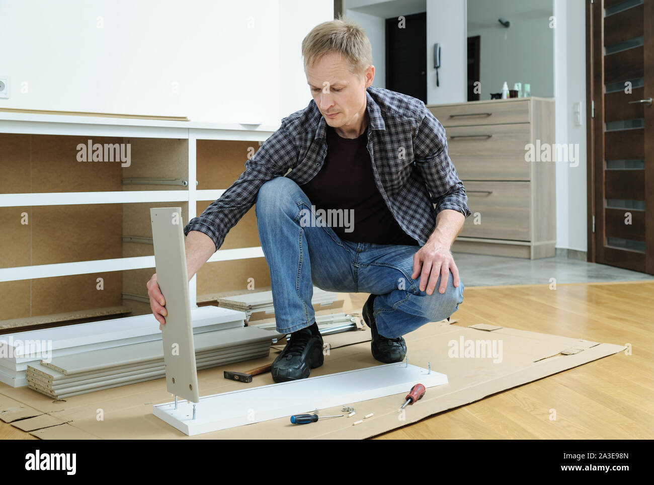 Mounting the chest of drawers. The man is joining the pieces of the ...