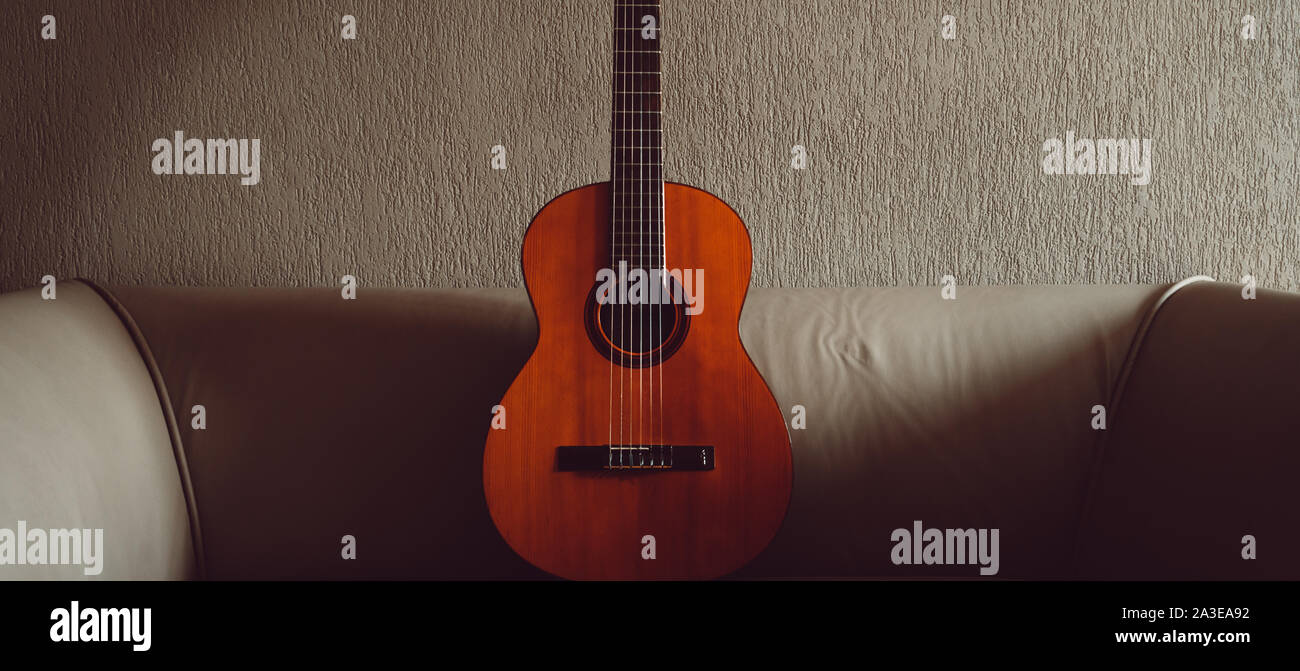Isolated acoustic guitar on a couch with lights and shadows Stock Photo ...