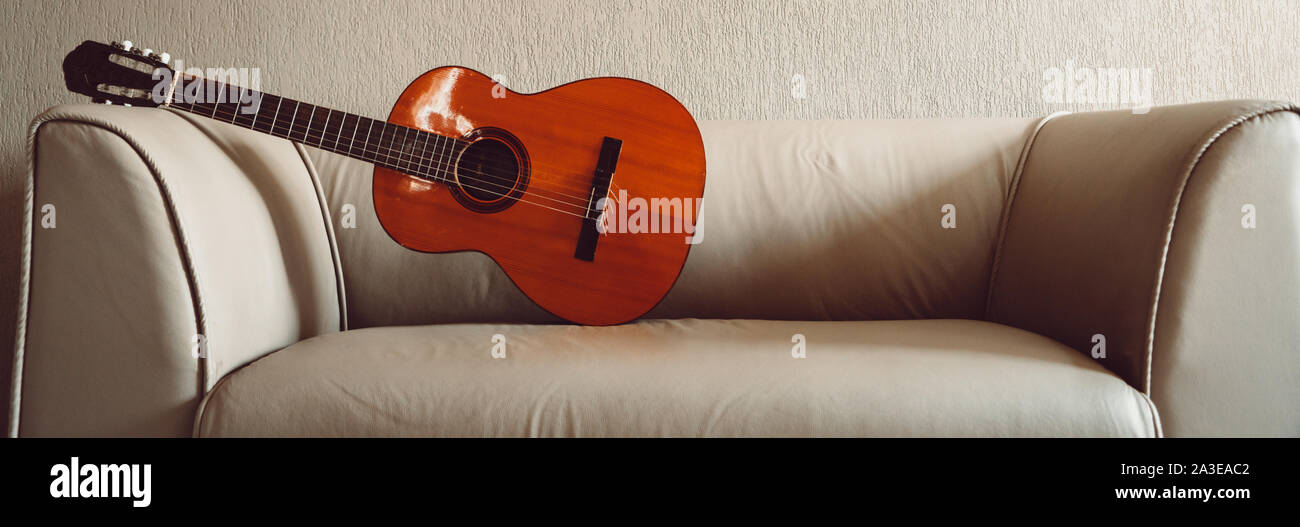 Isolated acoustic guitar on a couch with lights and shadows Stock Photo ...