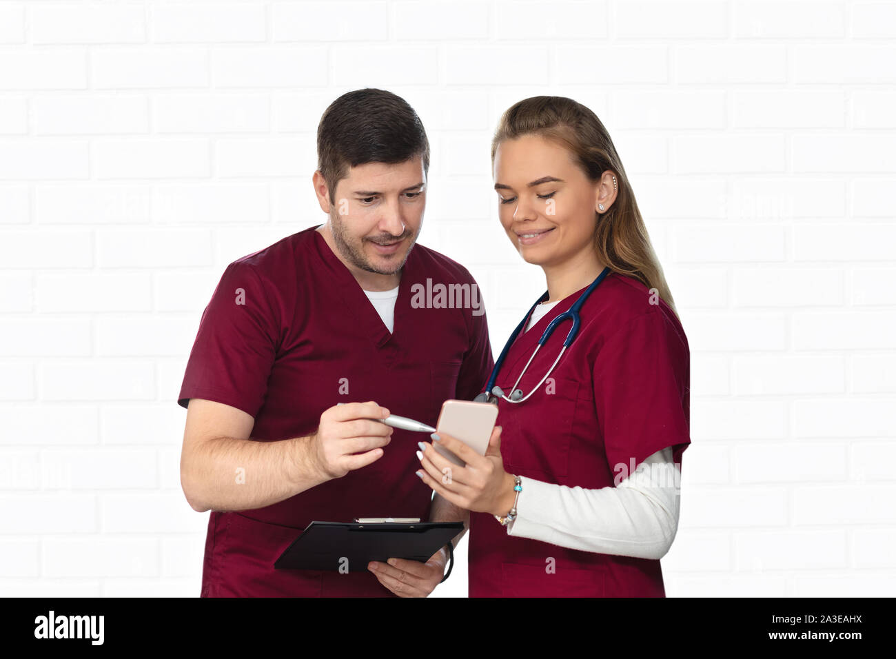 Medical team of modern doctor and nurse looking at phone consulting ...