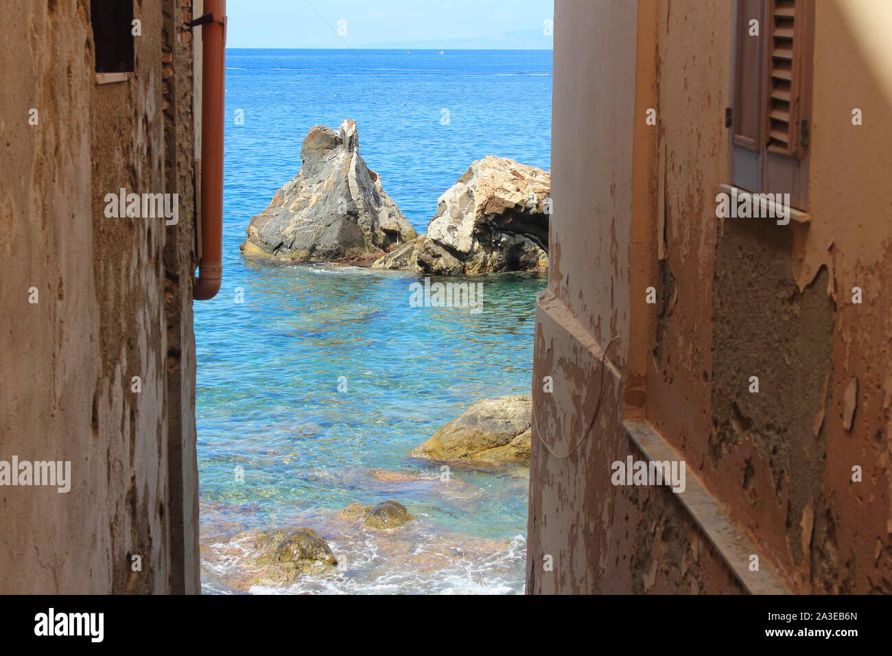 sea with rocks seen through the buildings of Scilla Stock Photo - Alamy
