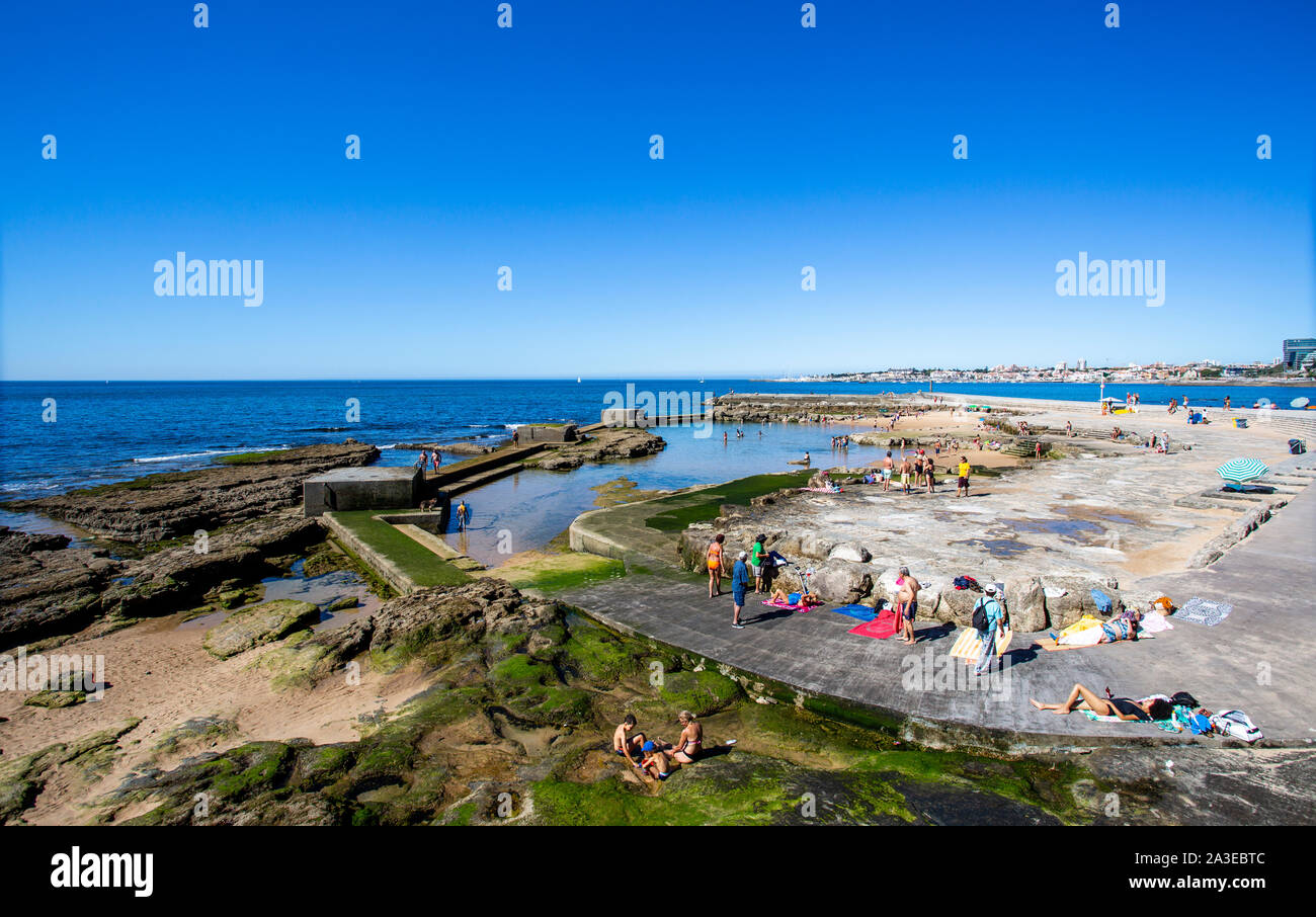 People enjoying the sun and the Atlantic Ocean around a swimming pool ...