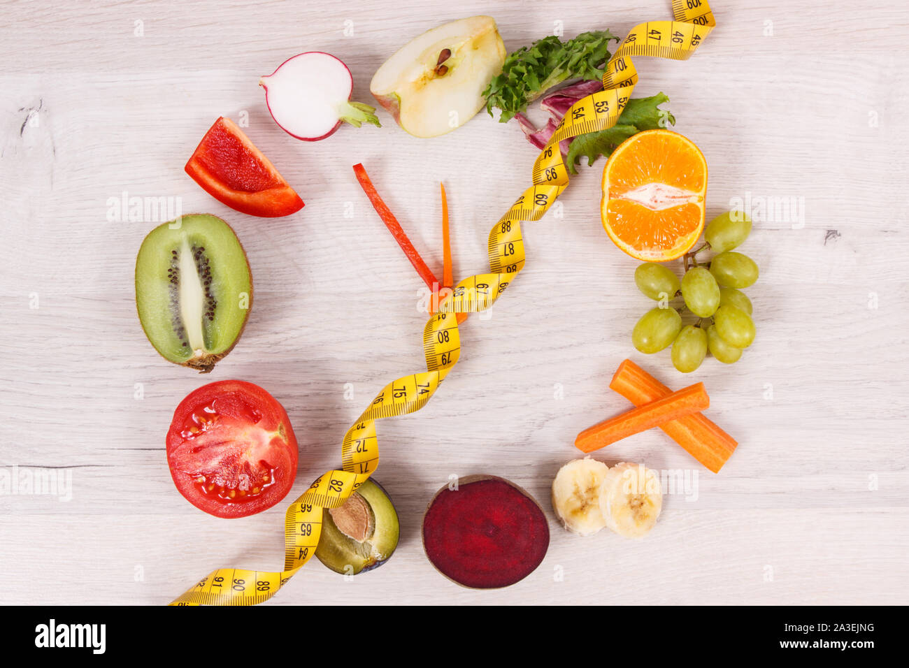Centimeter with fresh ripe fruits and vegetables in shape of clock ...