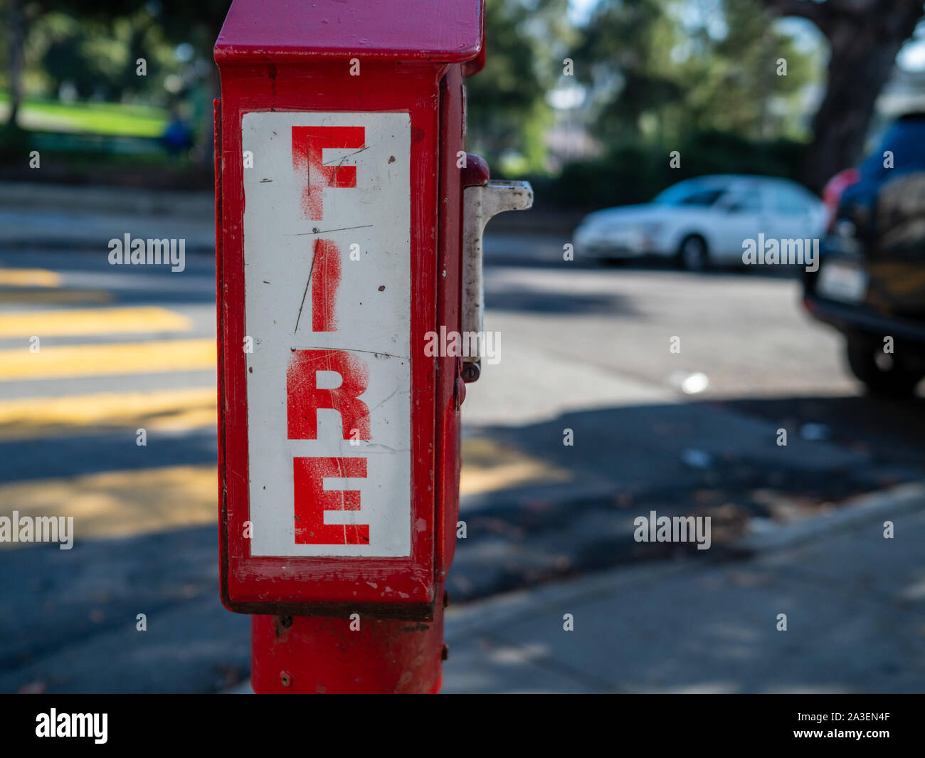 Outdoor fire alarm call box at urban intersection, fire in bold font ...