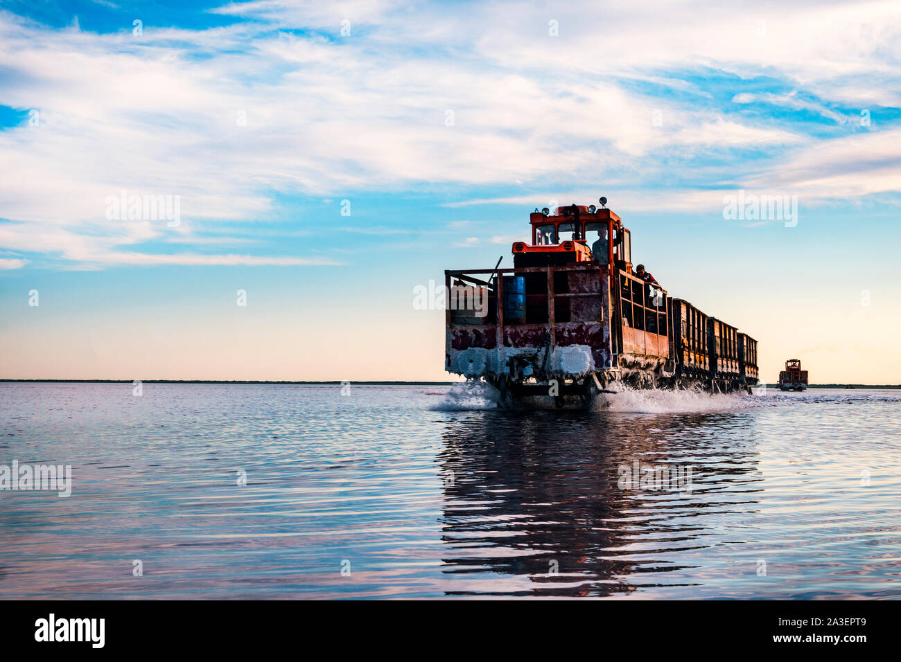 Old train rides on the railway laid in the water through the salt lake ...