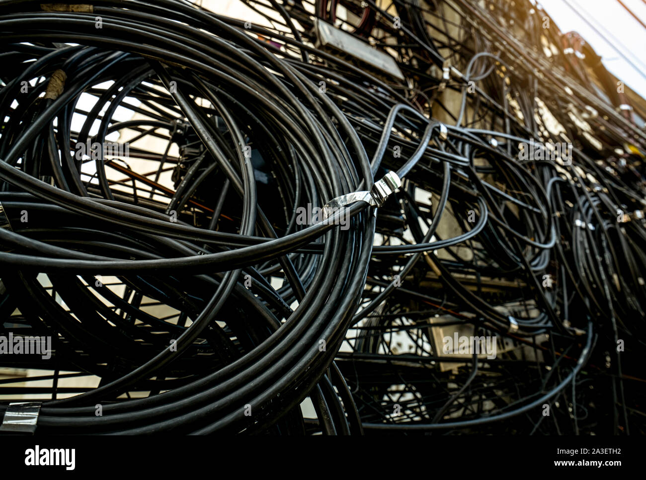 Tangled electrical wires on urban electric pole. Disorganized and messy ...