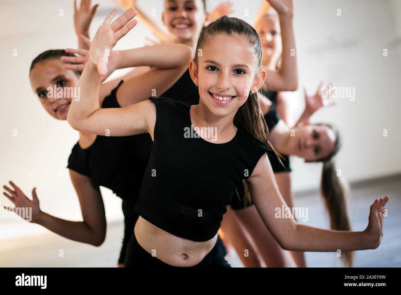 Group of fit happy children exercising dancing and ballet in studio ...
