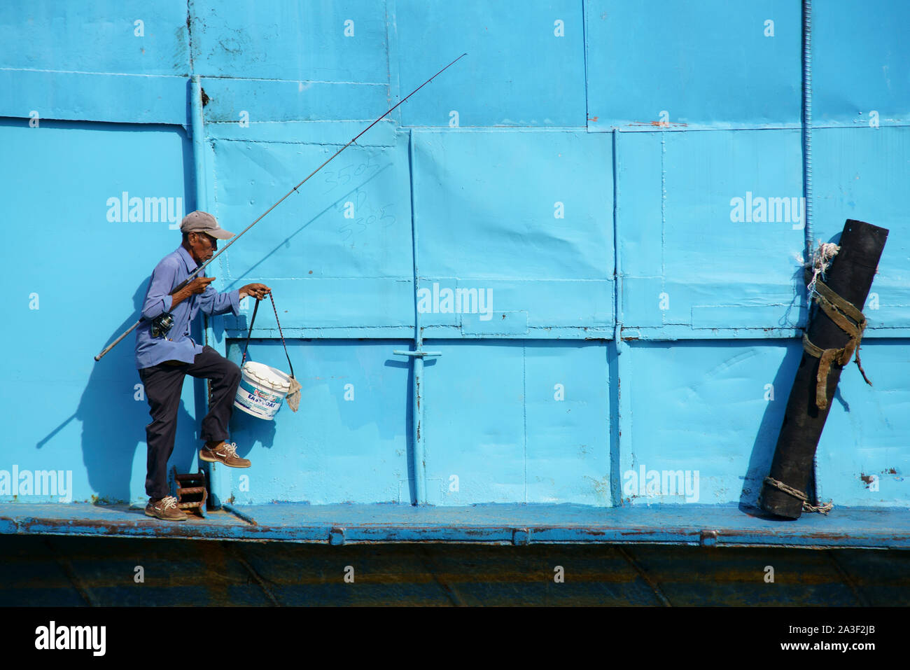 Sibu man negotiates a ledge to his fishing spot, Sibu Malaysia (Borneo ...
