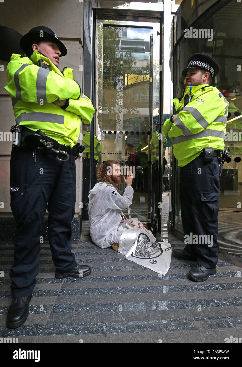 A protester who has glued himself to a door as part of an Extinction ...