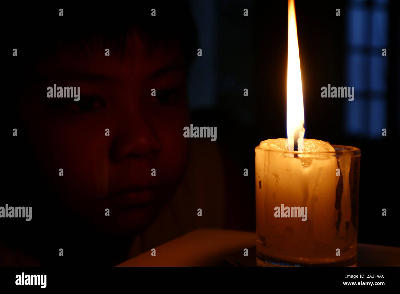 Photo of young child looking at candle Stock Photo - Alamy
