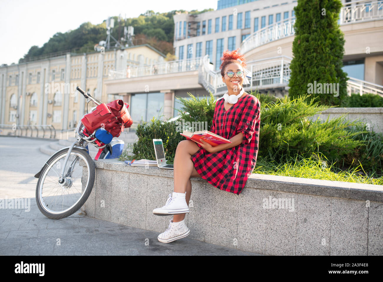 Student sitting outside and preparing for classes after riding bike ...