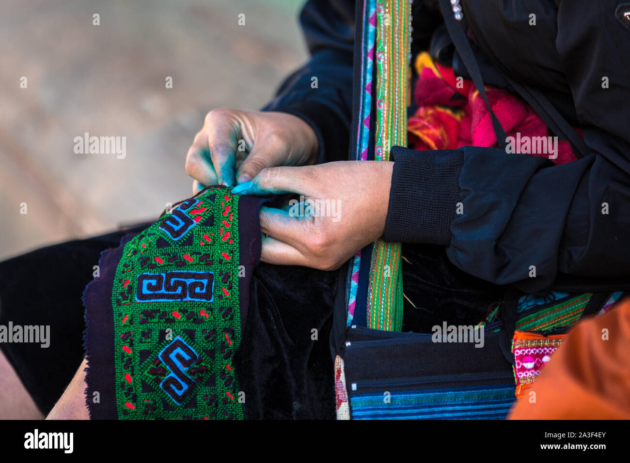 Ethnic Hmong woman weaving linen frabric with blue dye on her fingers ...